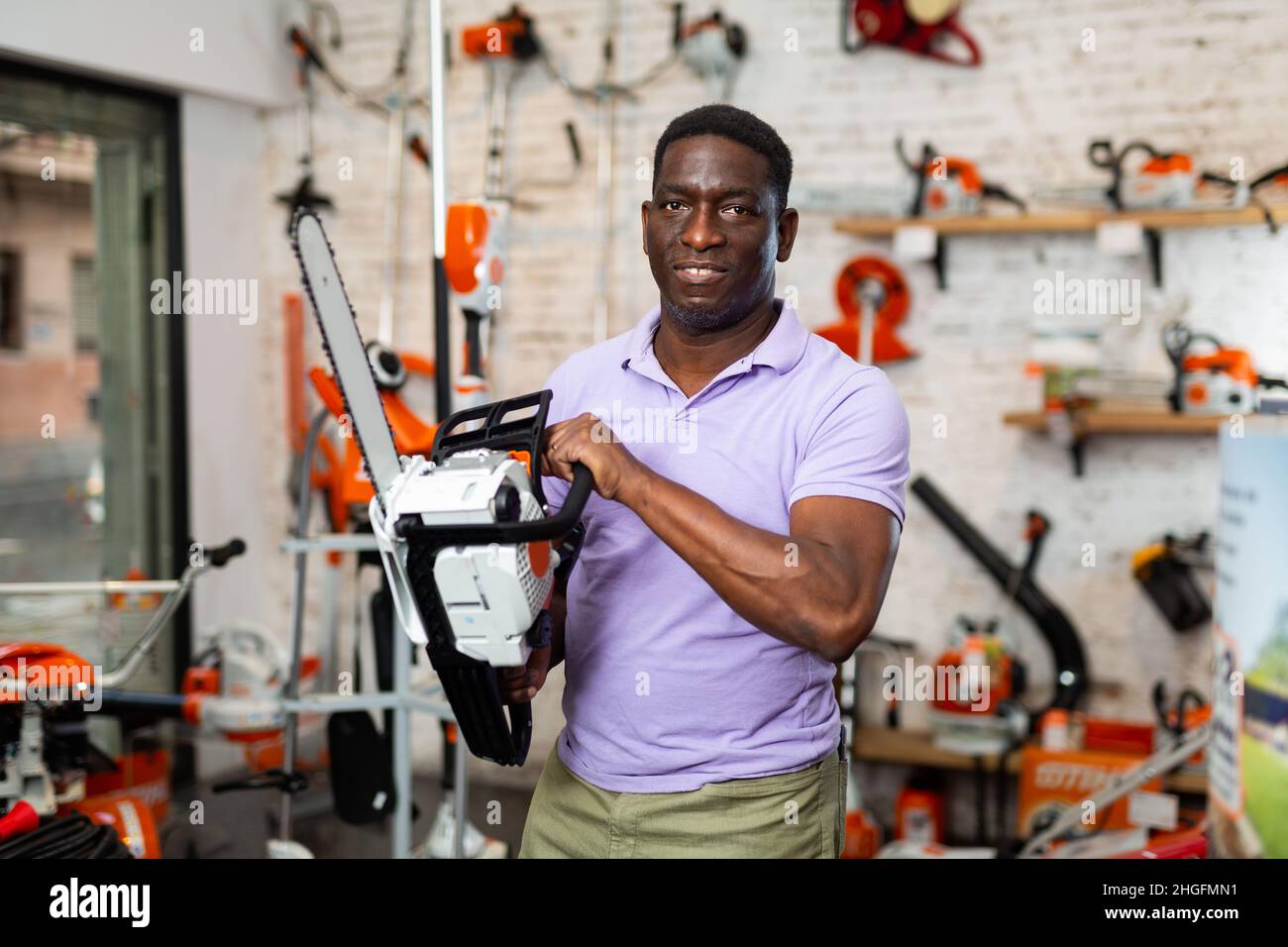 Ordinary man is buying new chainsaw in tool store Stock Photo - Alamy