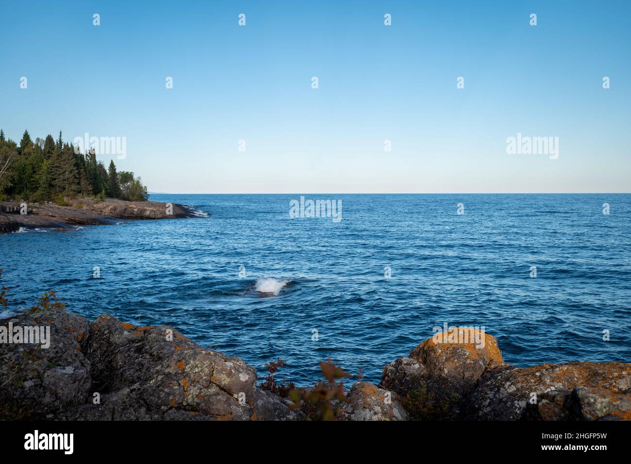 A single wave breaks over a submerged boulder near the rocky North ...