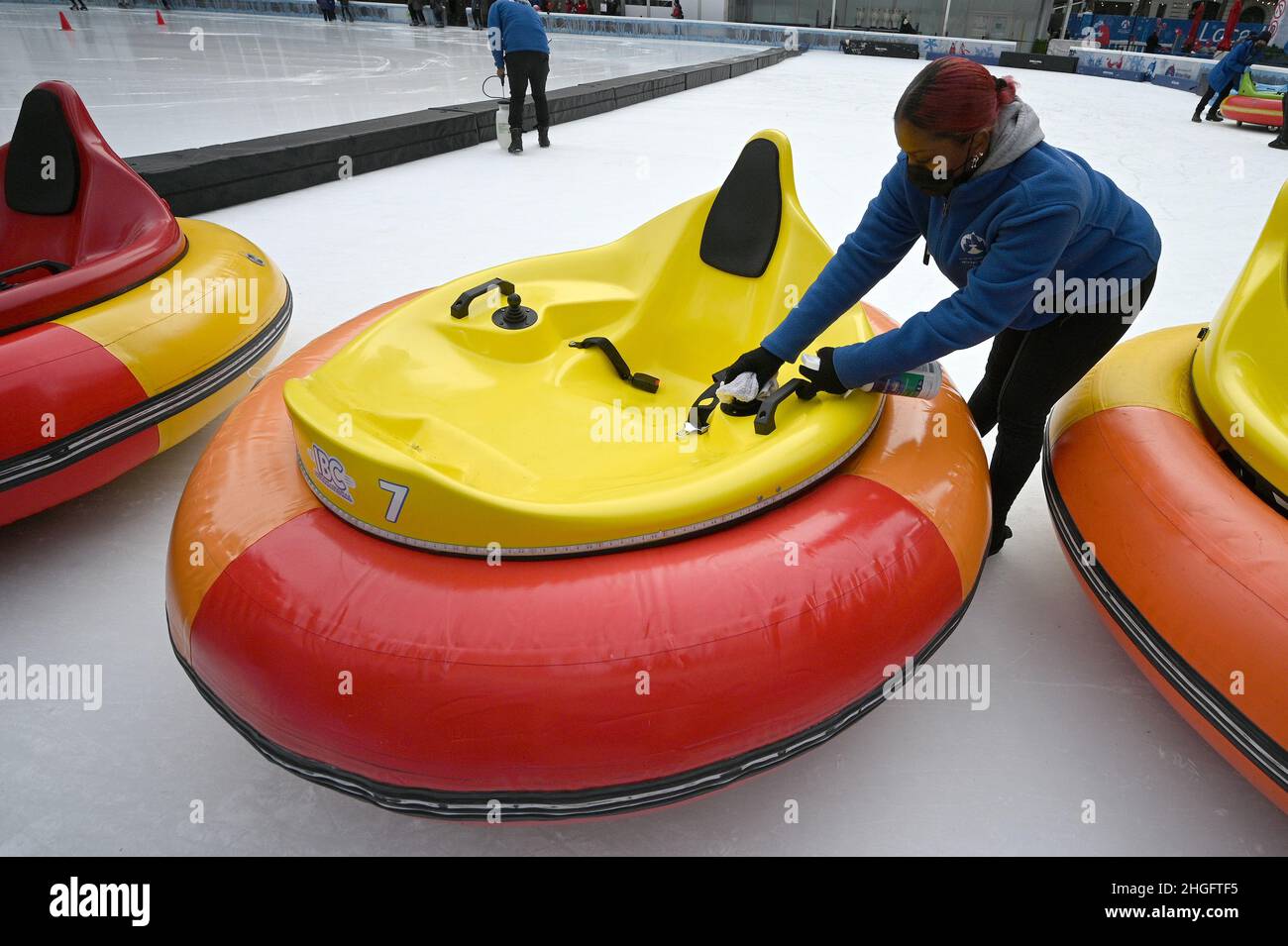New York, USA. 20th Jan, 2022. A park employee wipes down a bumper car ...