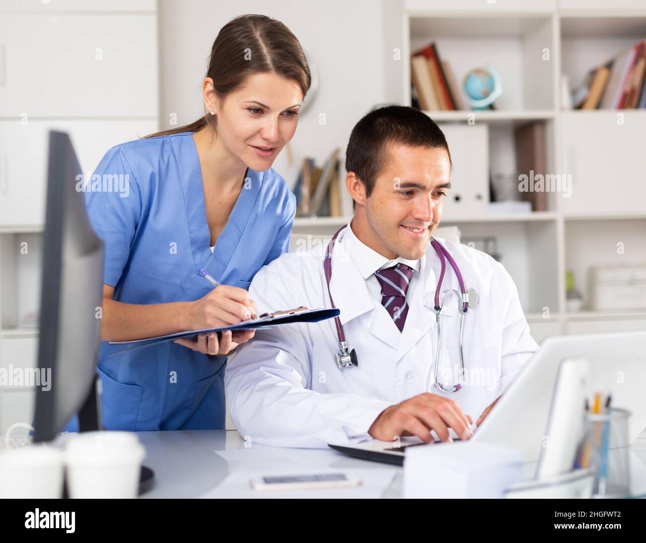 Doctor and nurse check patient data in computer database Stock Photo ...