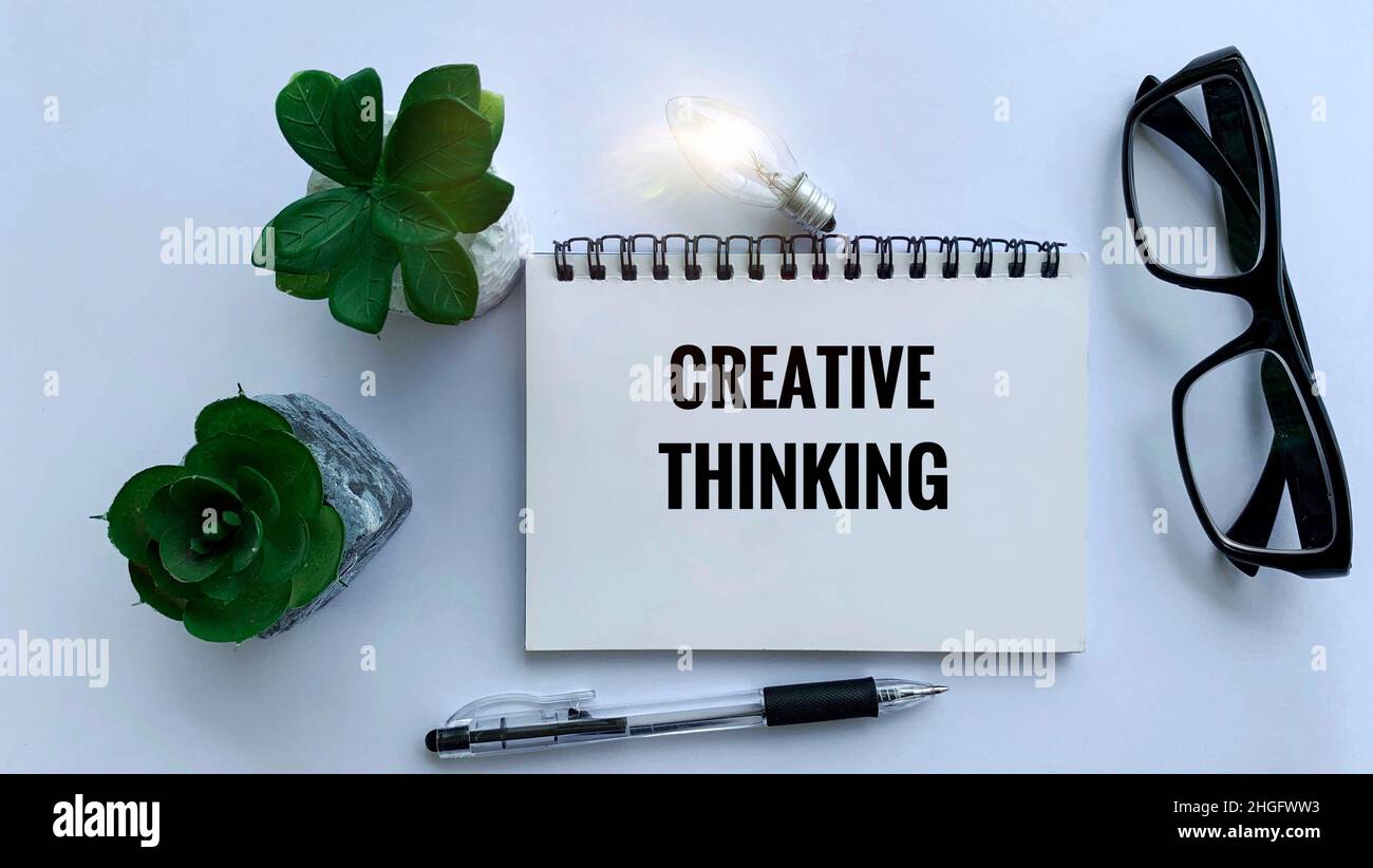 Creative thinking text on notepad with light bulb, glasses, pen and ...