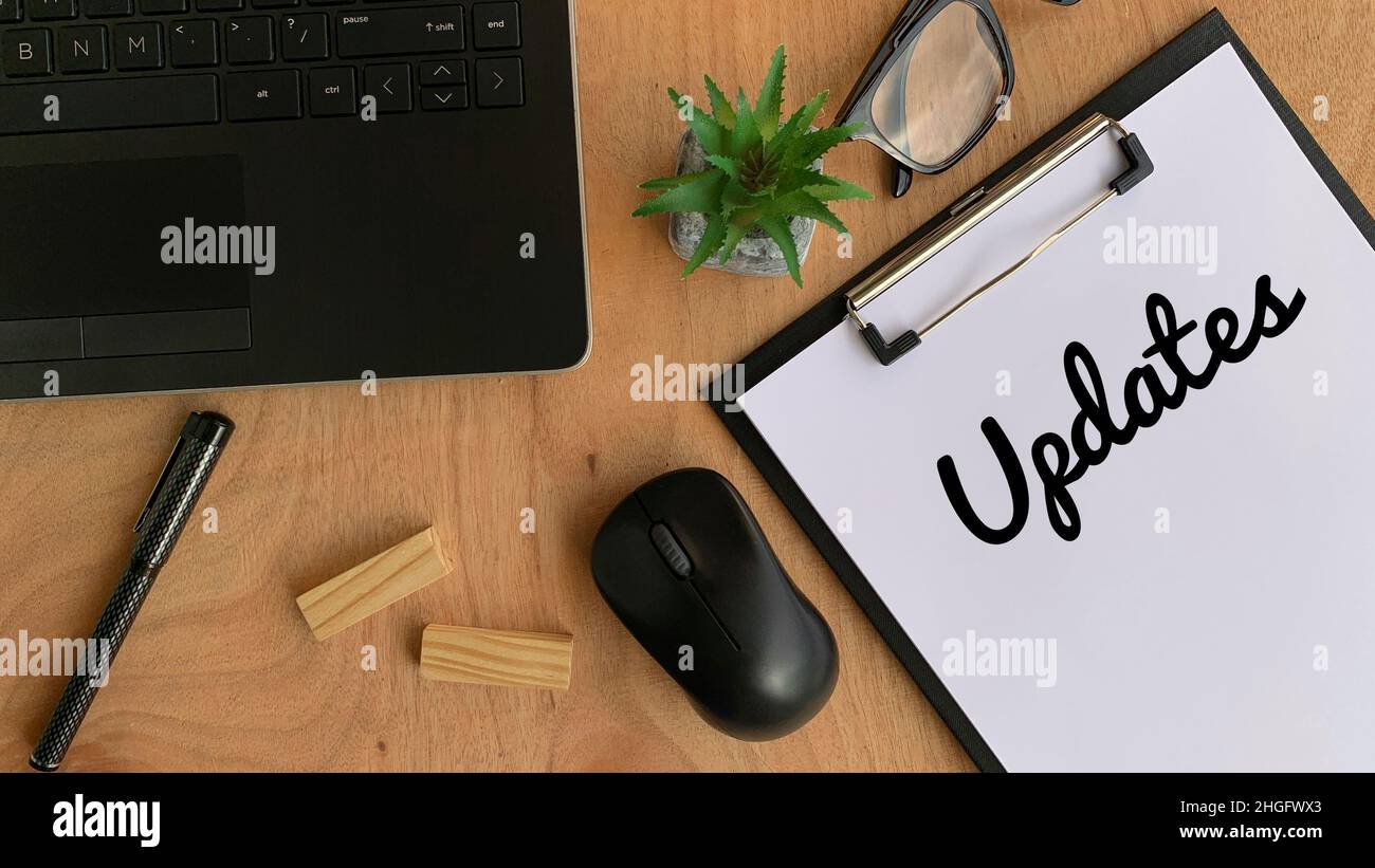 Updates word written on a piece of paper. With glasses, mouse, wooden ...