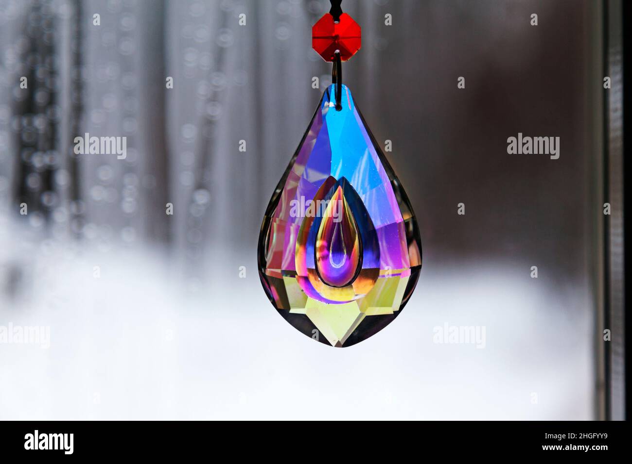 crystal in the colors of the rainbow against a gray and dull background ...