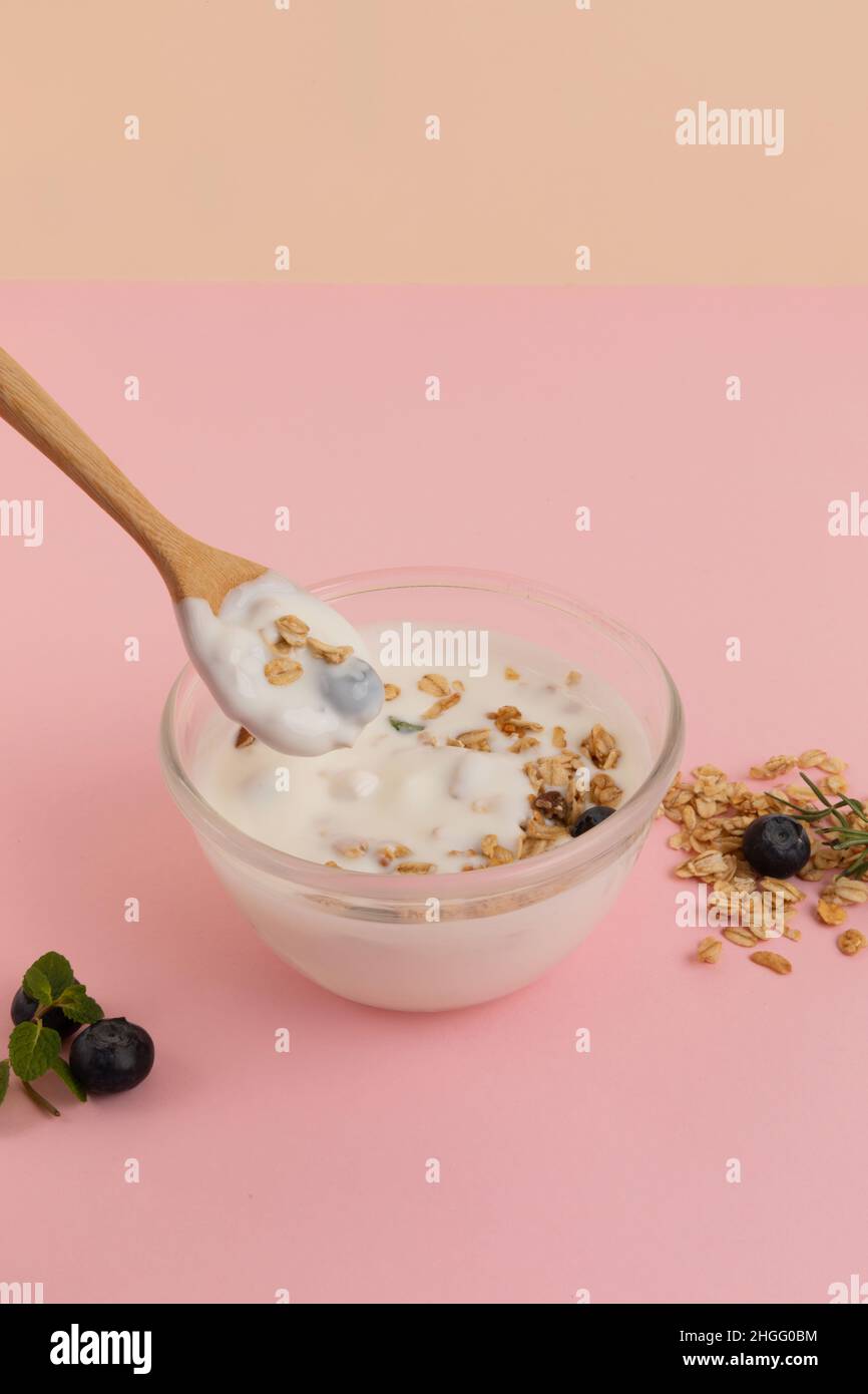 scooping yogurt with a spoon in pink background Stock Photo - Alamy
