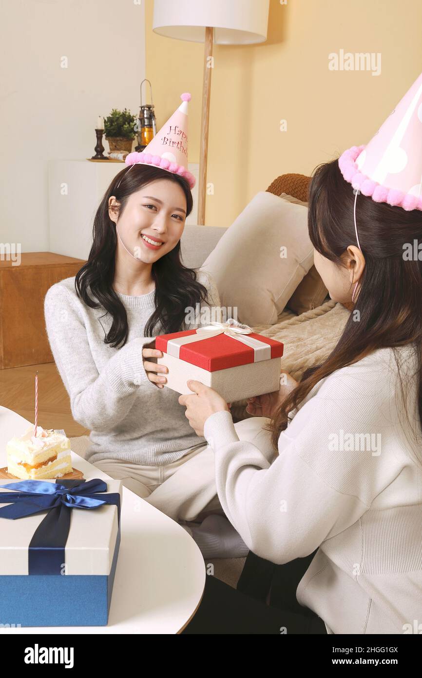 asian korean women best friends sharing gift Stock Photo - Alamy