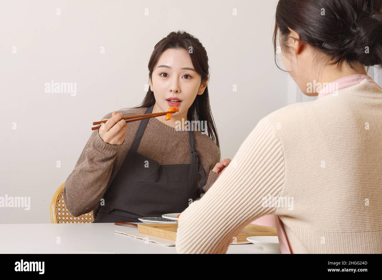 asian korean women eating after cooking together, spending time indoors ...