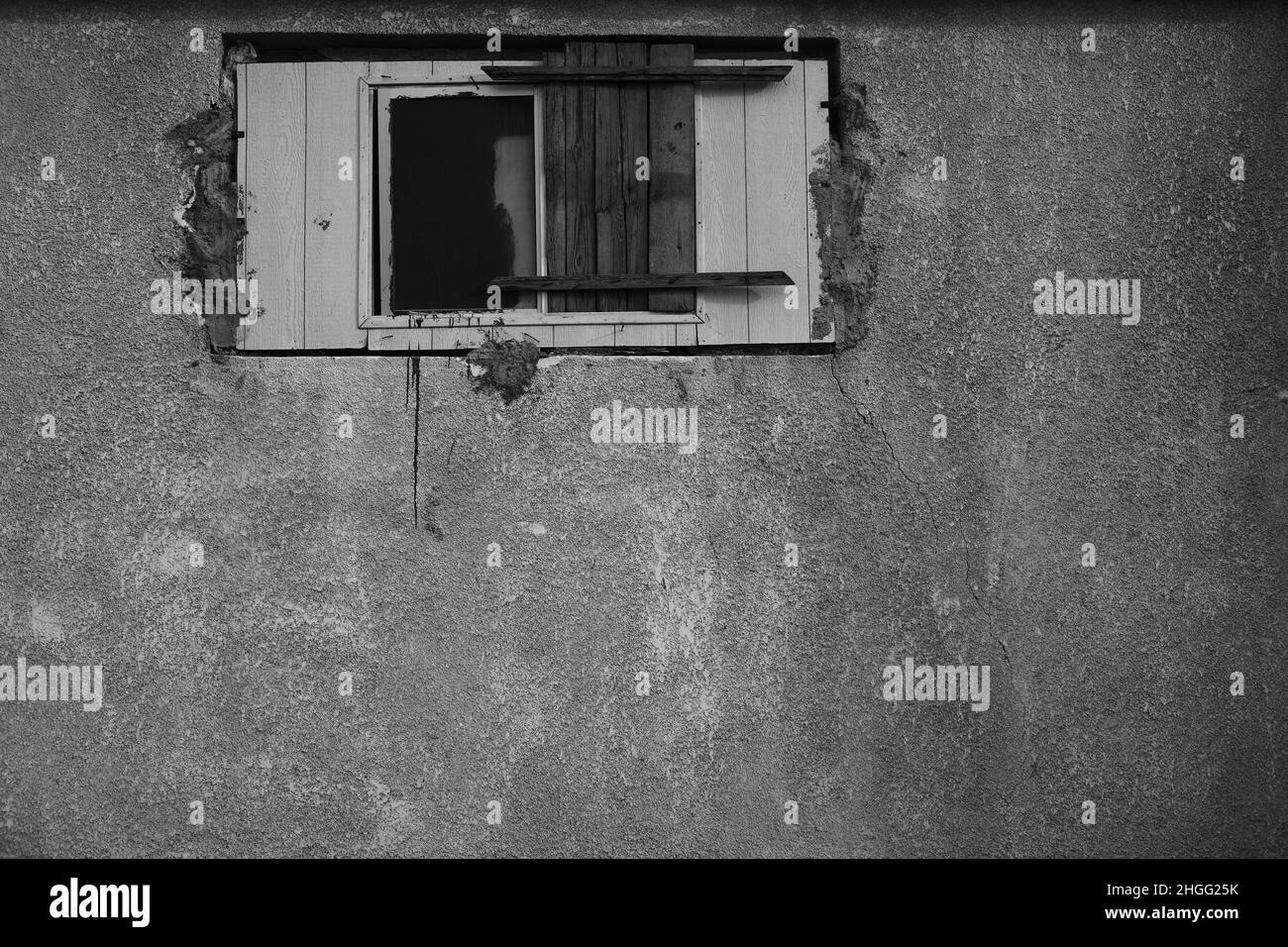 Small window in a concrete wall half boarded up Stock Photo - Alamy