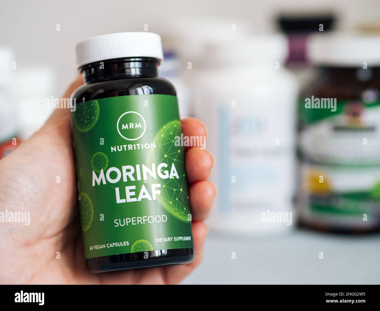 Moscow, Russia - March 09, 2021: Jar with Moringa Leaf capsules by MRM in female hand and others ...