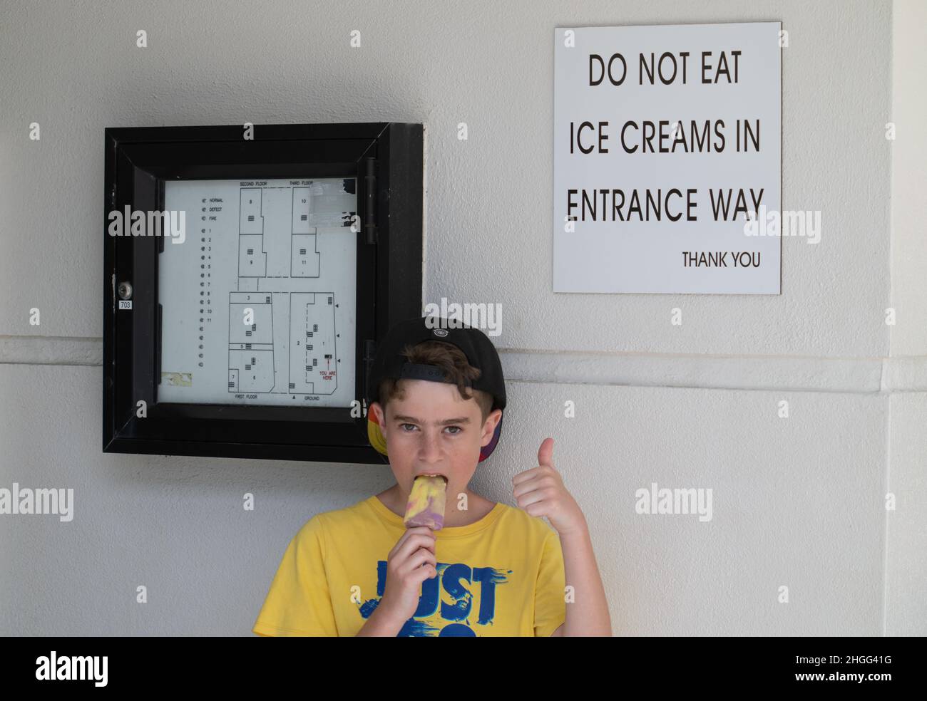 Tauranga New Zealand - January 17 2022; Boy eats ice cream under sign ...