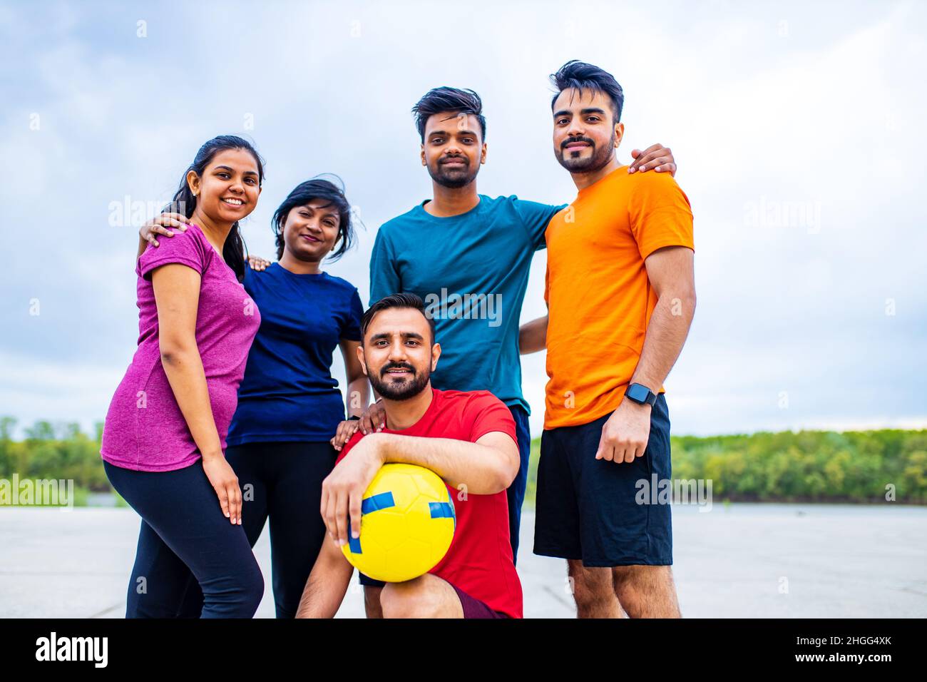 four indian people warming up outdoors in sport wear morning time urban ...