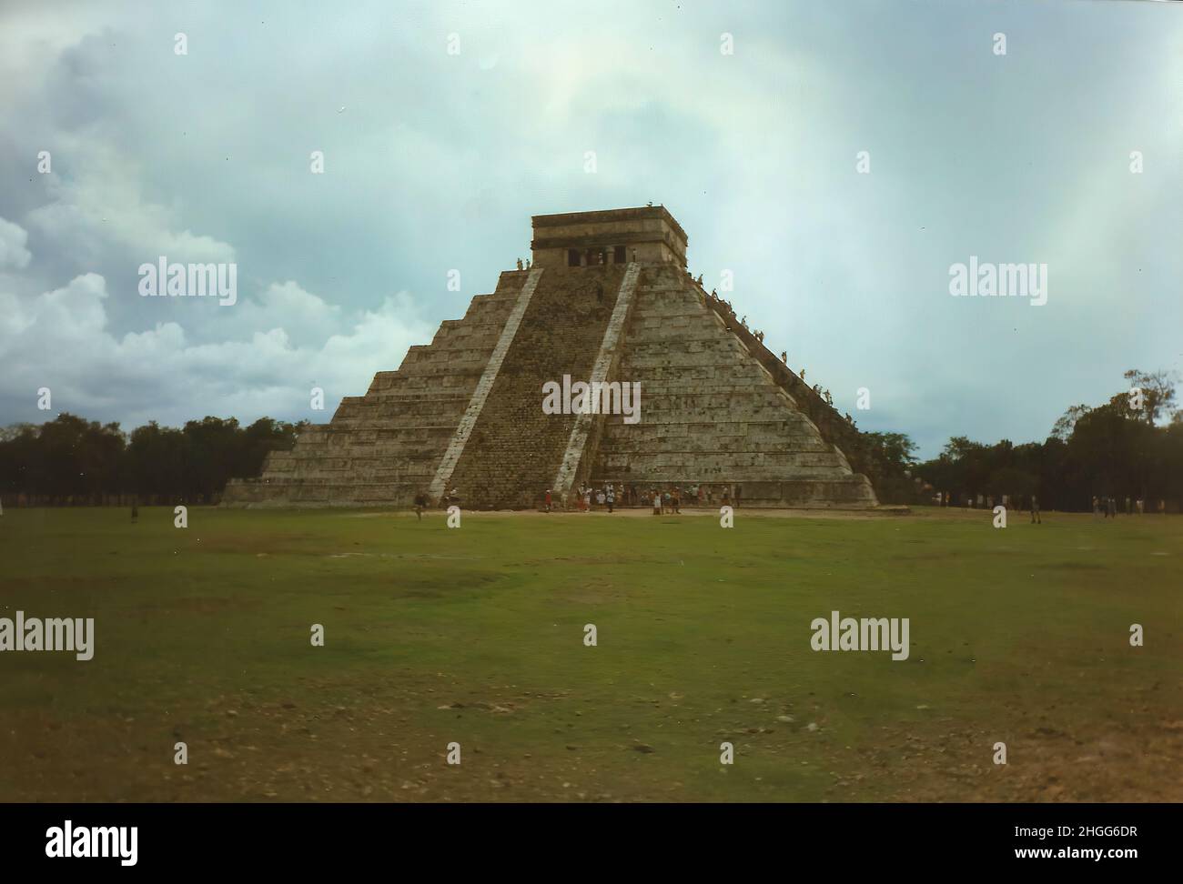 Tourists climbing the main pyramid of the Mayan ruins at Chichen Itza ...
