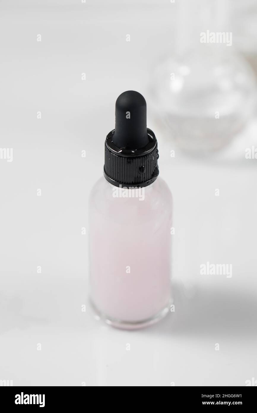Pink dropper with skin serum on a white background. Anti-aging ...