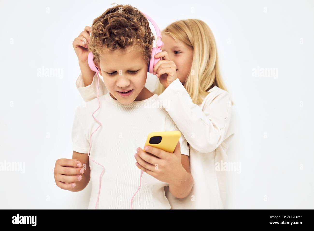 Two preschool children boy and girl smiling with phone in hand fashion ...