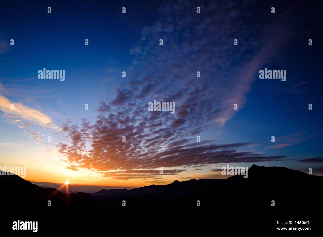 cirrus altucumulus clouds on a sunrise blue sky with orange shiny sky ...