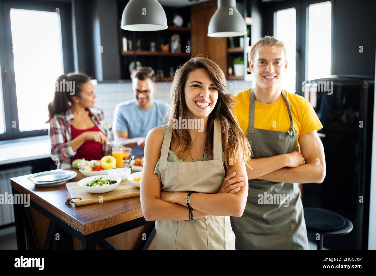 Group of happy friends having fun in kitchen, cooking food together ...