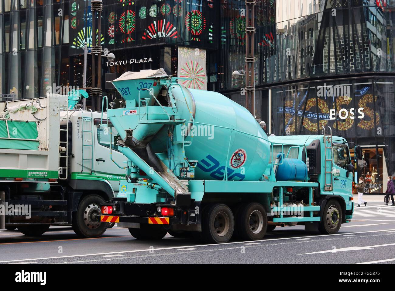 TOKYO, JAPAN - January 20, 2022: A cement mixer truck and a industrial ...