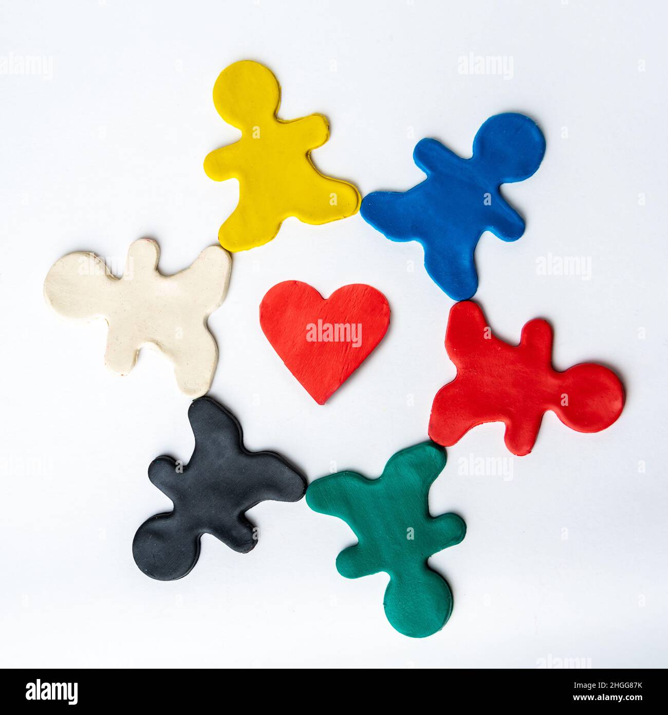 Red heart shape in the center and multicolored bright plasticine people ...