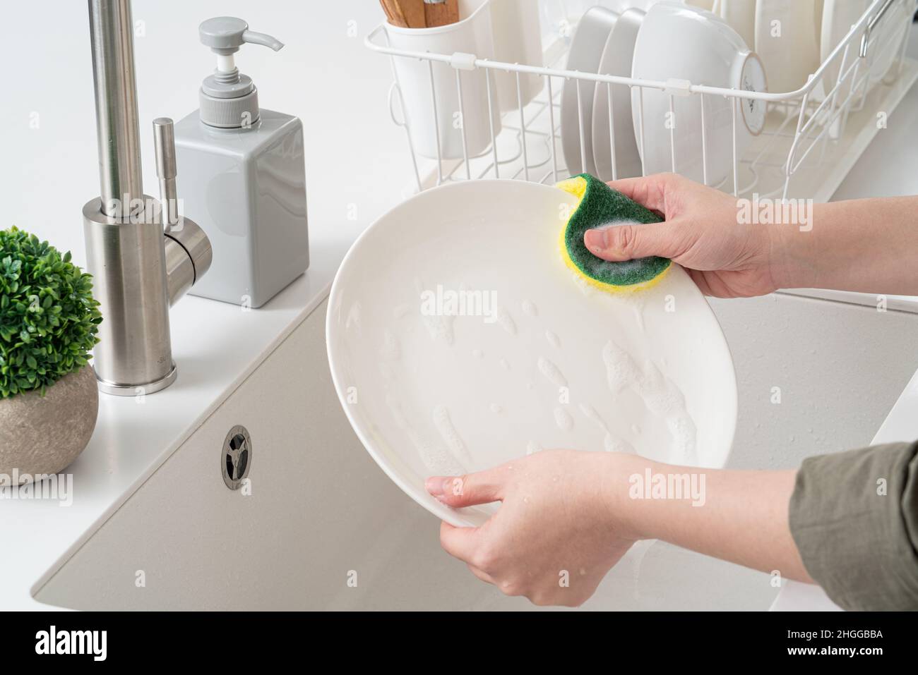 Close up of woman housewife is doing the dishes at home kitchen by ...
