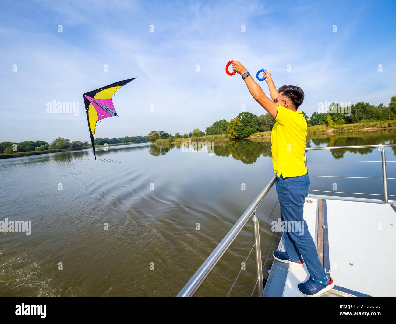 young man is standing on terrace of floating house and trying to fly ...
