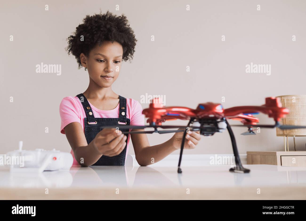 Little girl holding quadcopter. Child playing with drone at home ...