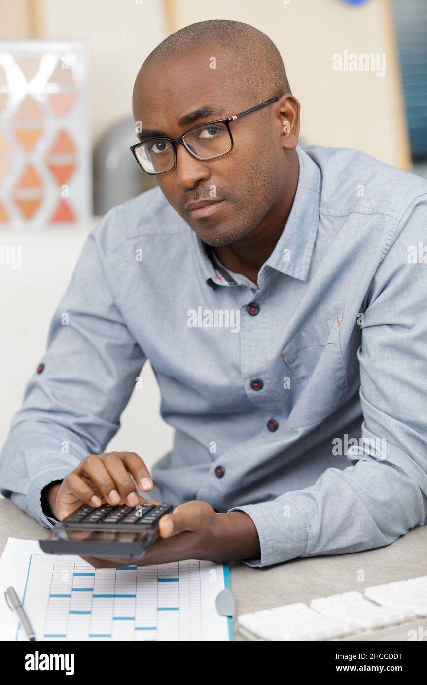 serious man with the calculator in the office Stock Photo - Alamy
