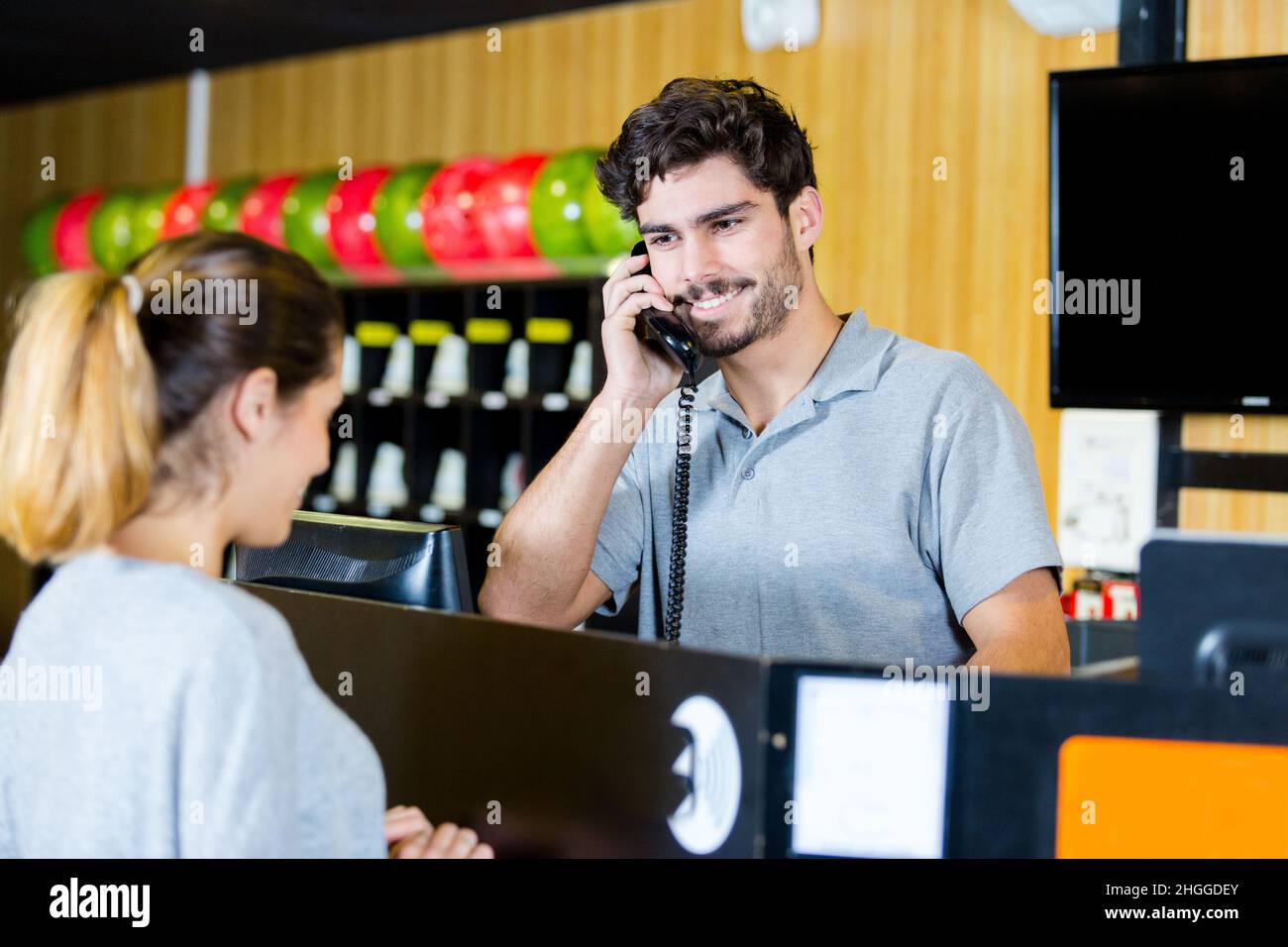 lady at reception desk of bowling hall Stock Photo - Alamy