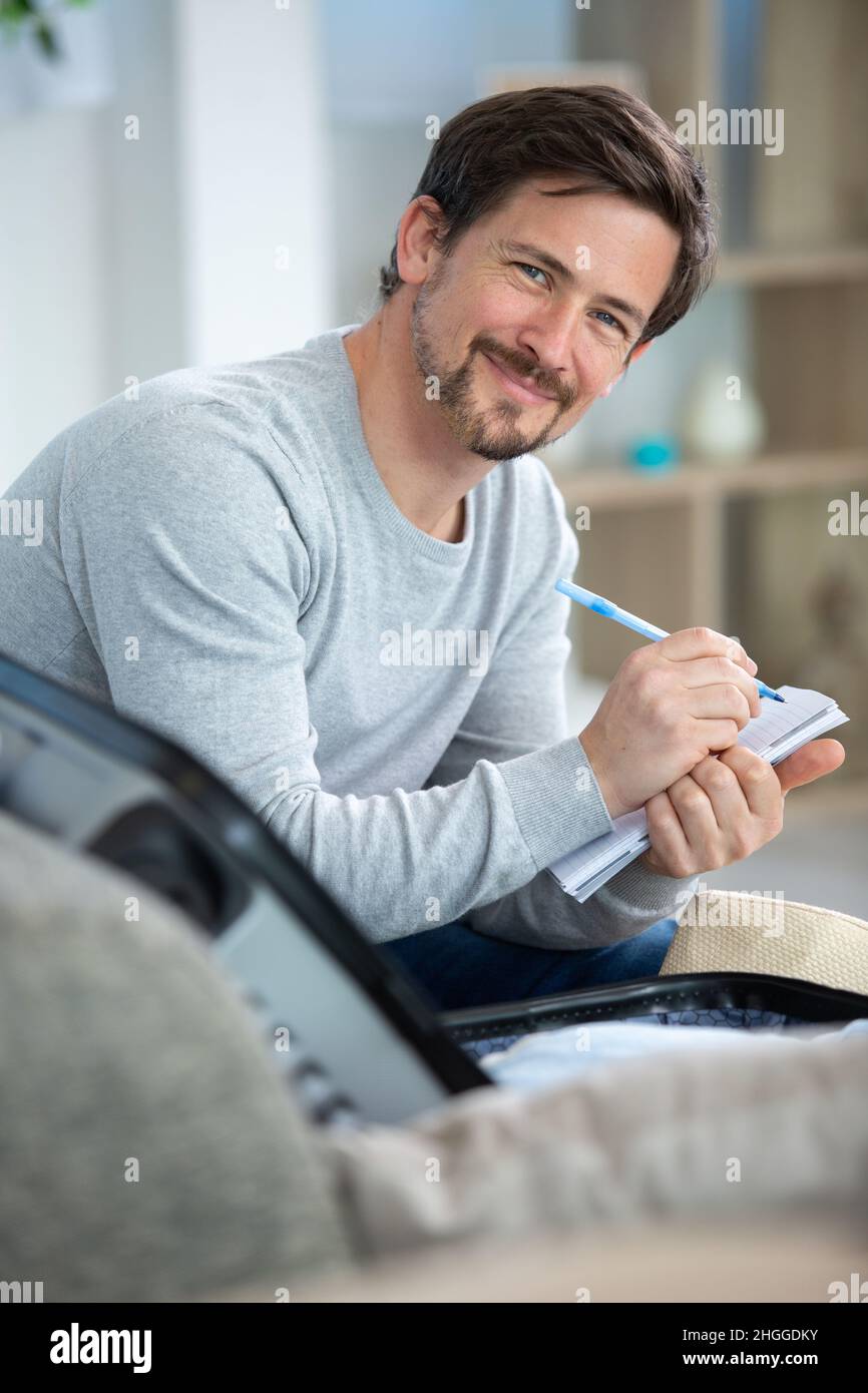 man packing the luggage he note and call check Stock Photo - Alamy