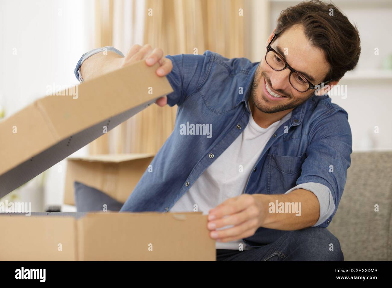 Happy man opening parcel hi-res stock photography and images - Alamy