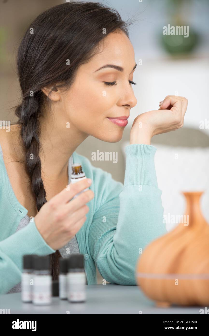 young woman applying perfume on her wrist and smelling Stock Photo - Alamy