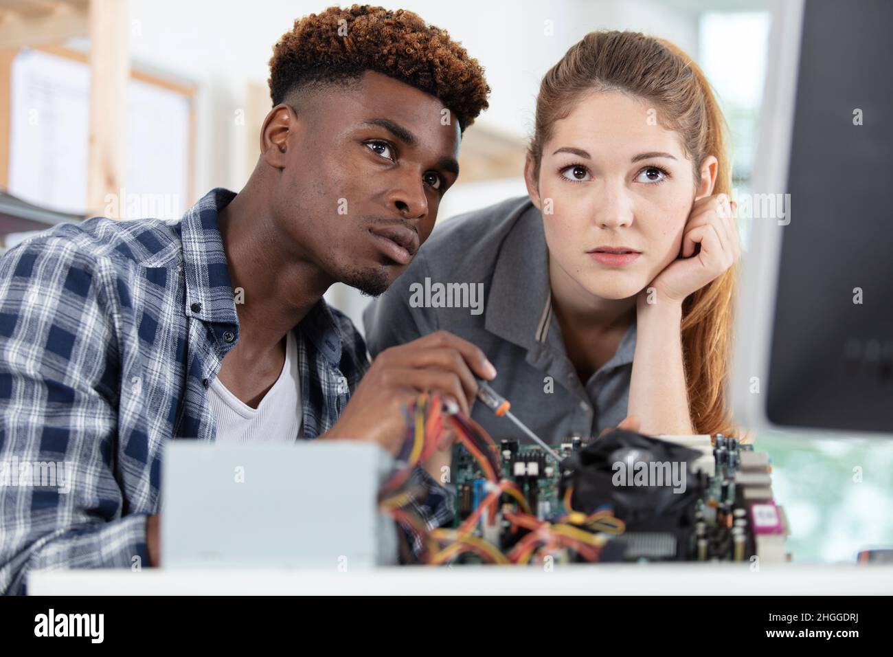 two technicians working at computer warranty center Stock Photo - Alamy
