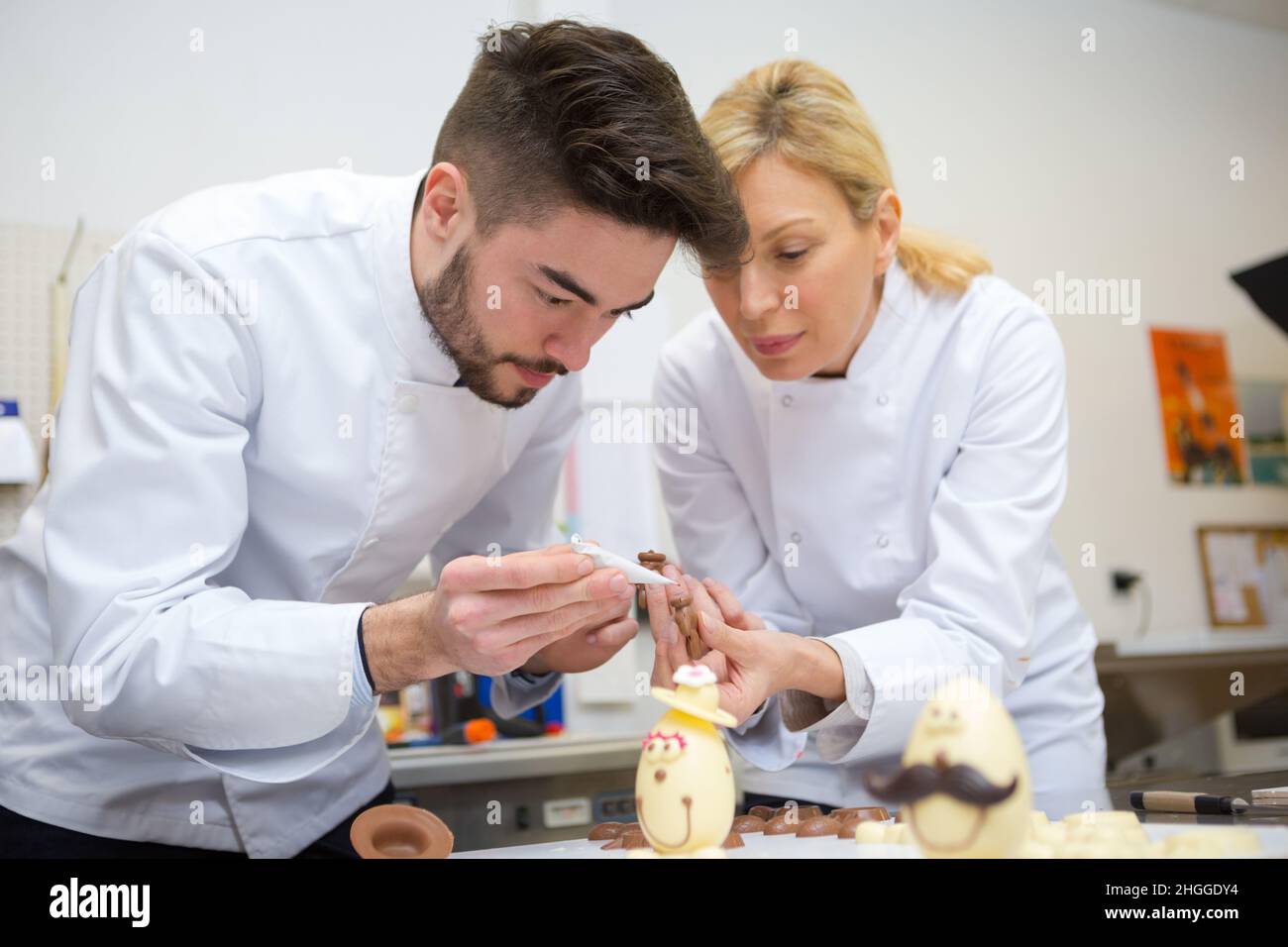 young chocolatier making topping designs on the chocolates Stock Photo ...