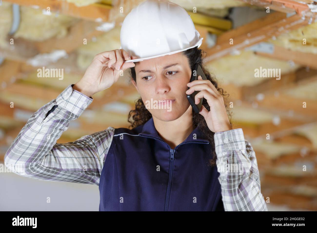 young woman builder confused on the phone Stock Photo - Alamy
