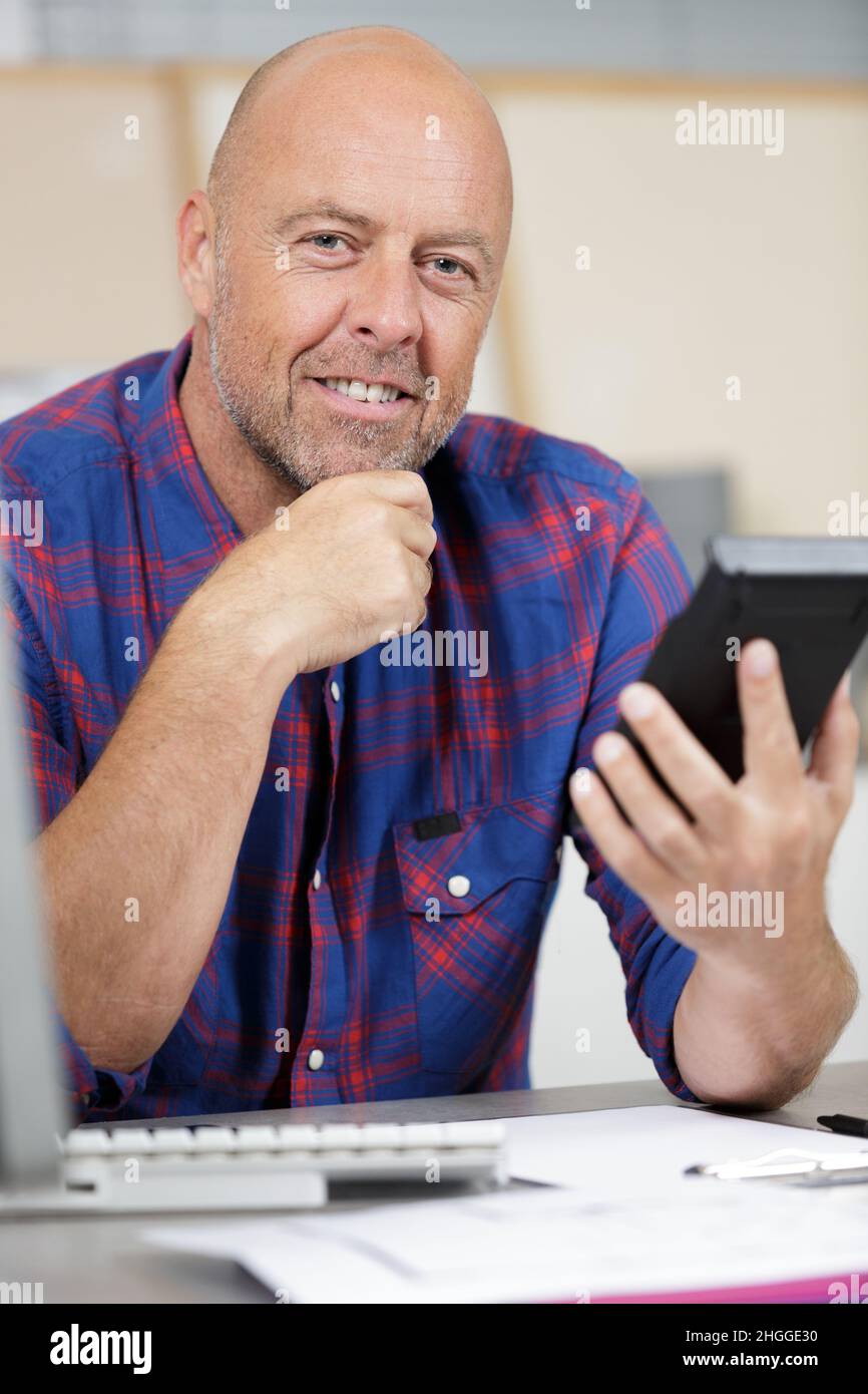 senior man sat at desk doing calculations Stock Photo - Alamy