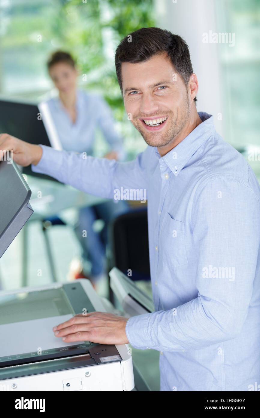 happy man is doing documents copies on copying machine Stock Photo - Alamy