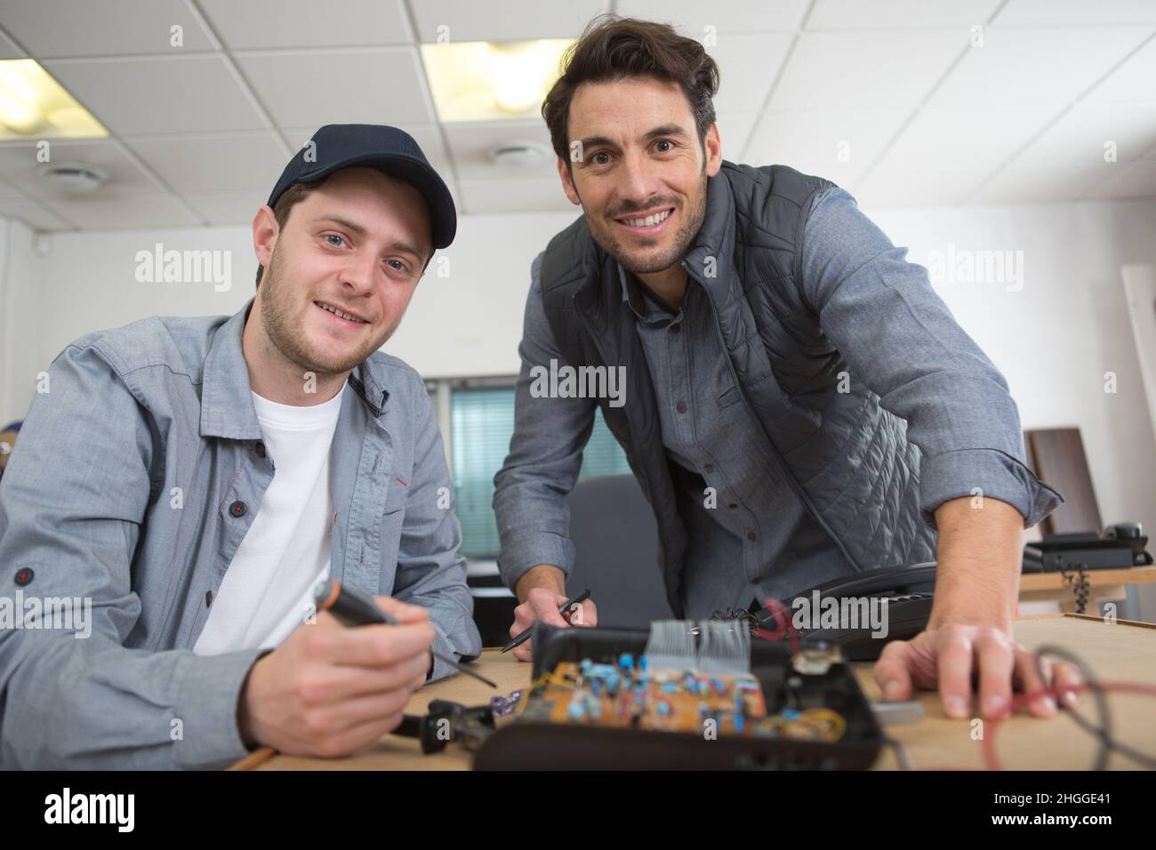 two men repairing hardware equipment from pc Stock Photo - Alamy