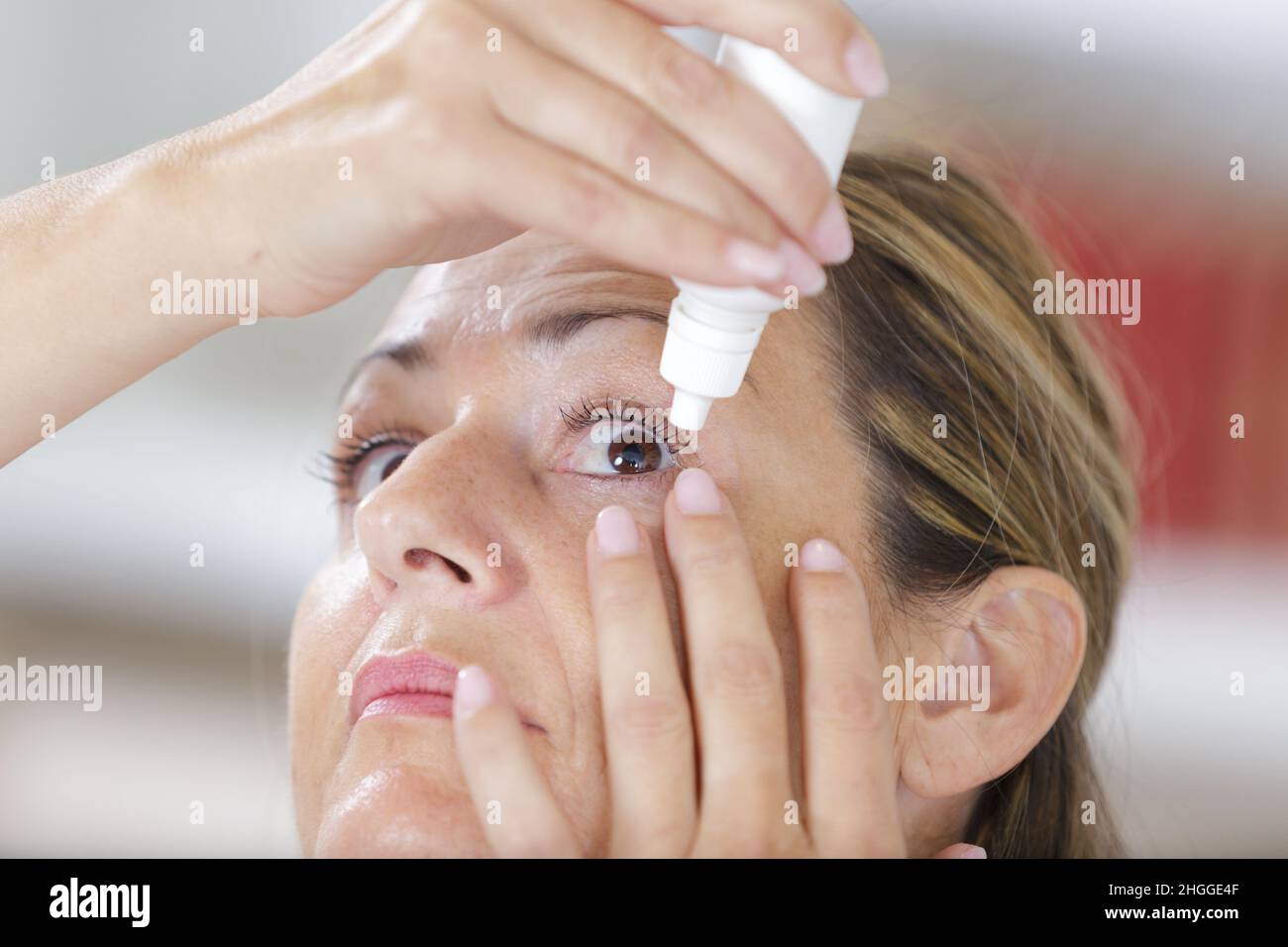 a woman using eye lotion Stock Photo - Alamy