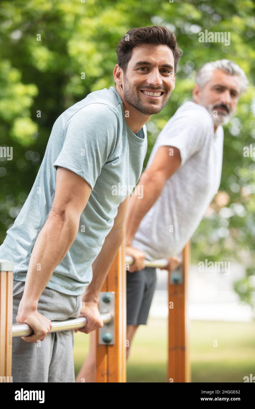 two men exercising on bars in a modern fitness park Stock Photo - Alamy