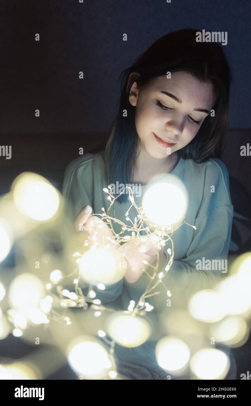 Beautiful teenager girl with light garland at home. Night scene Stock ...