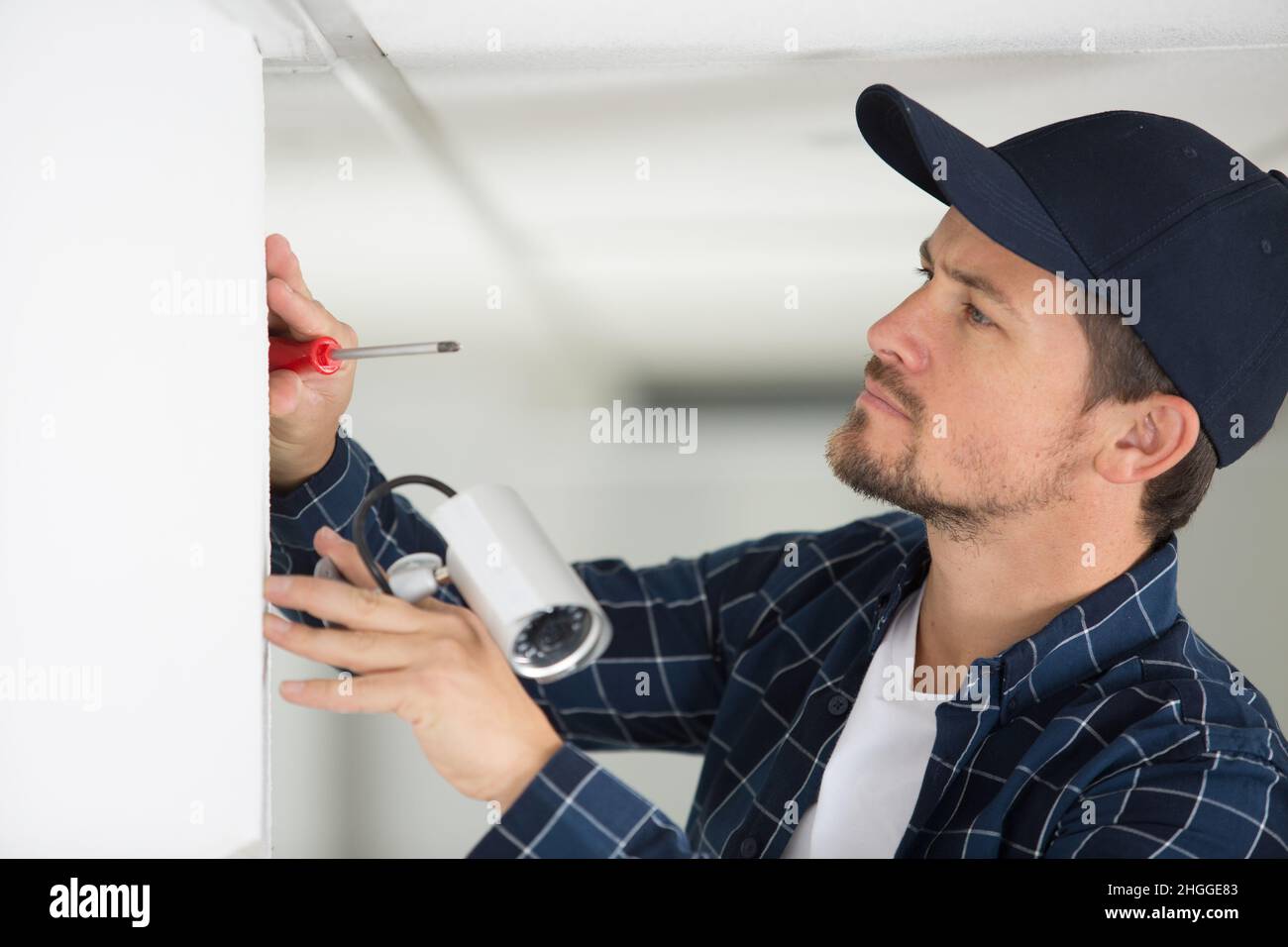 electrician installs a cctv camera Stock Photo - Alamy