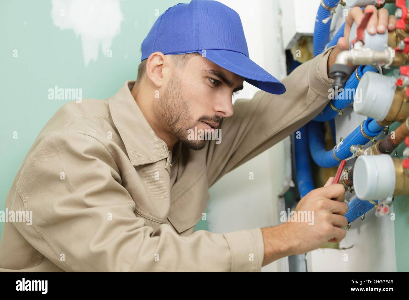male plumber fixing water meter with adjustable wrench Stock Photo - Alamy