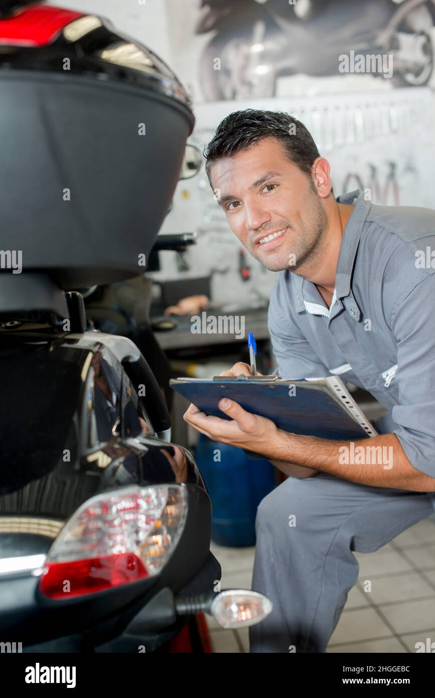 a mechanic is holding clipboard Stock Photo - Alamy
