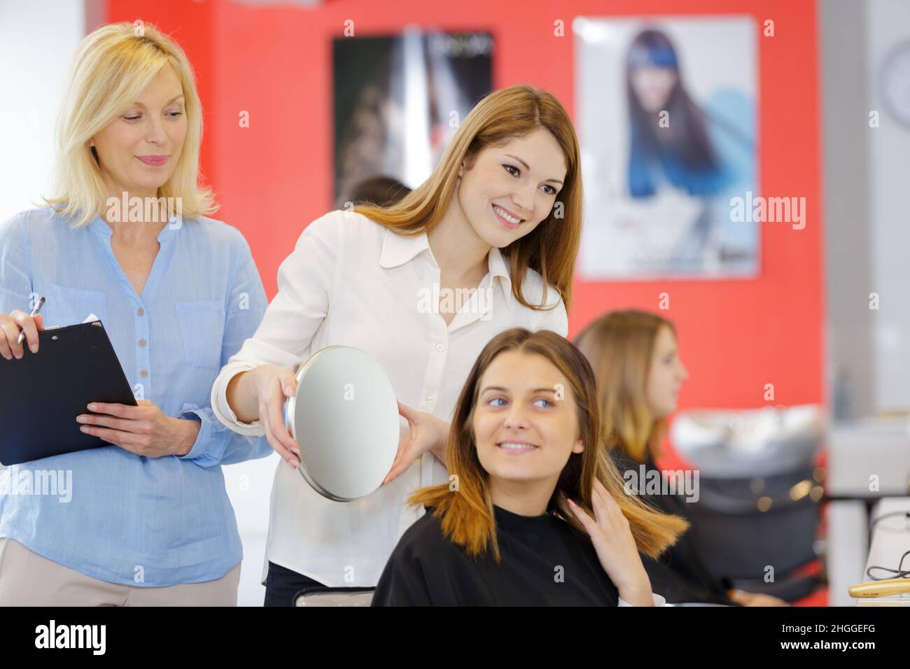 teacher helping students training to become hairdressers Stock Photo ...