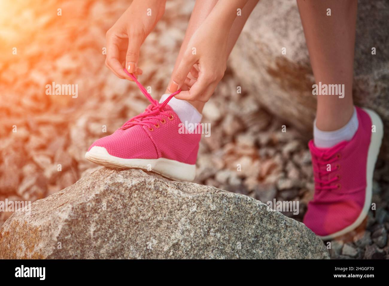 Attractive female runner tying shoe hi-res stock photography and images - Alamy