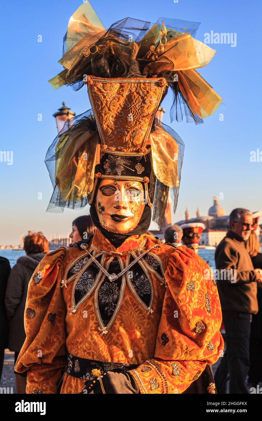 Participant in colourful orange fancy dress historic costume, hat and ...