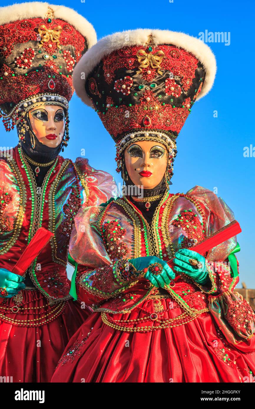 Two women in beautiful historic red fancy dress costumes and hats pose ...
