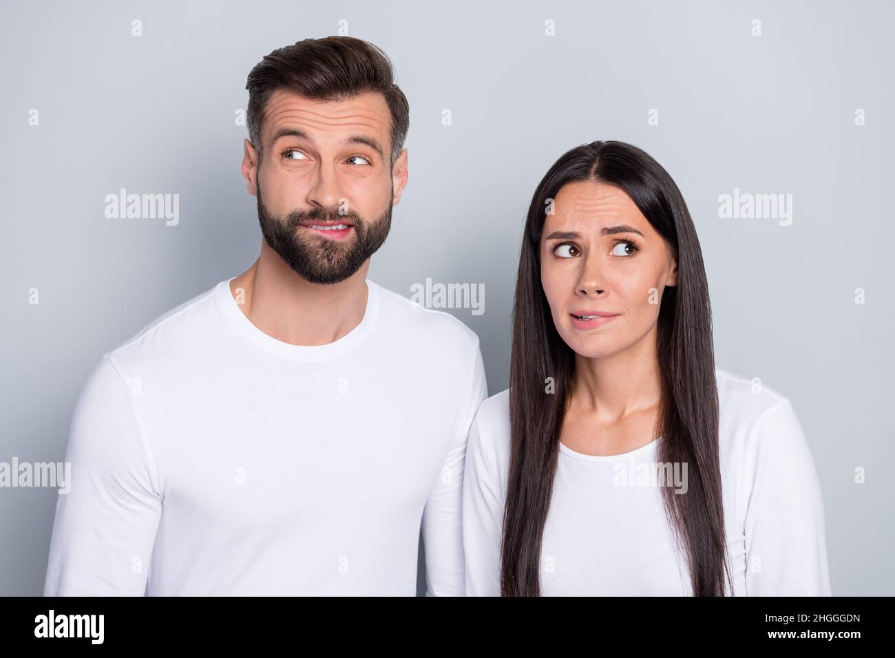 Photo of scared brother sister dressed white shirts biting lips looking ...