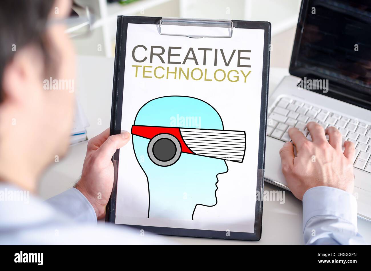 Man holding a clipboard with creative technology concept Stock Photo ...
