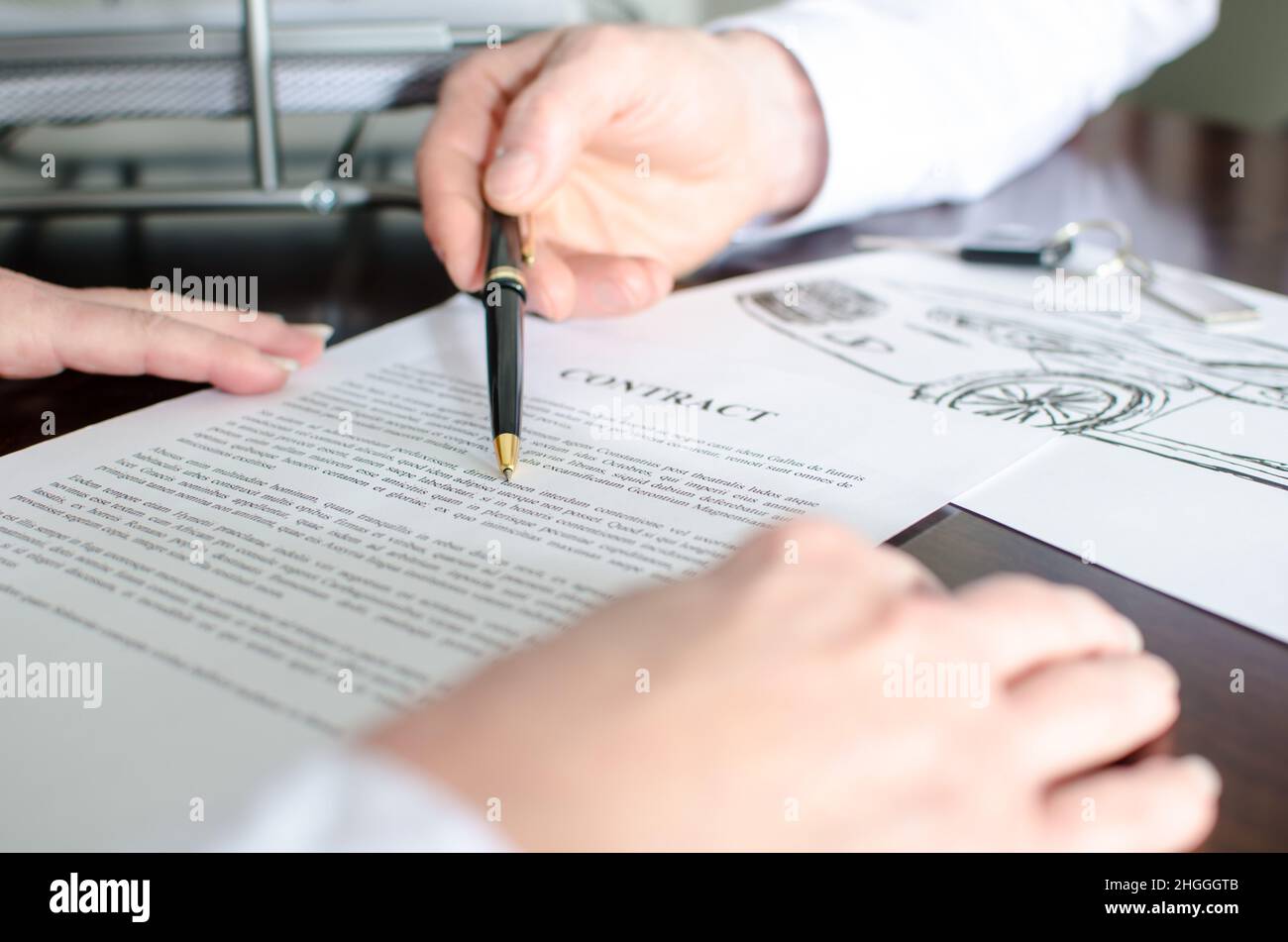 Dealer showing a detail of a car purchase contract with his pen Stock ...