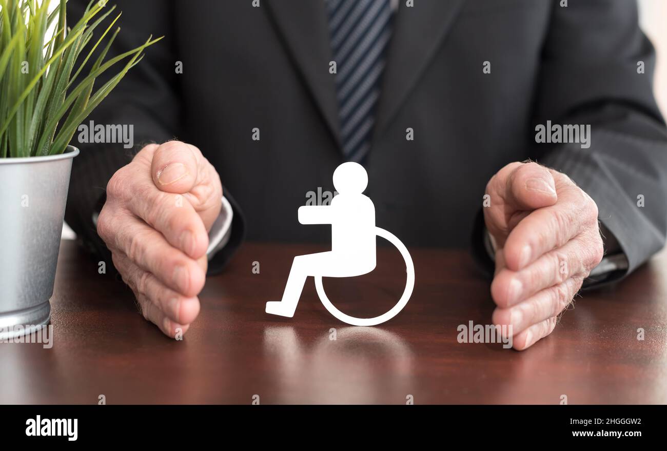 Insurer protecting a disabled person with his hands Stock Photo - Alamy