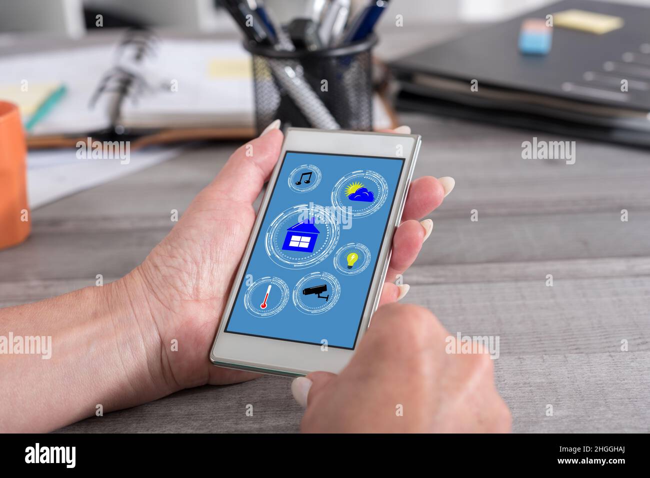 Female hand holding a smartphone with smart home automation concept ...